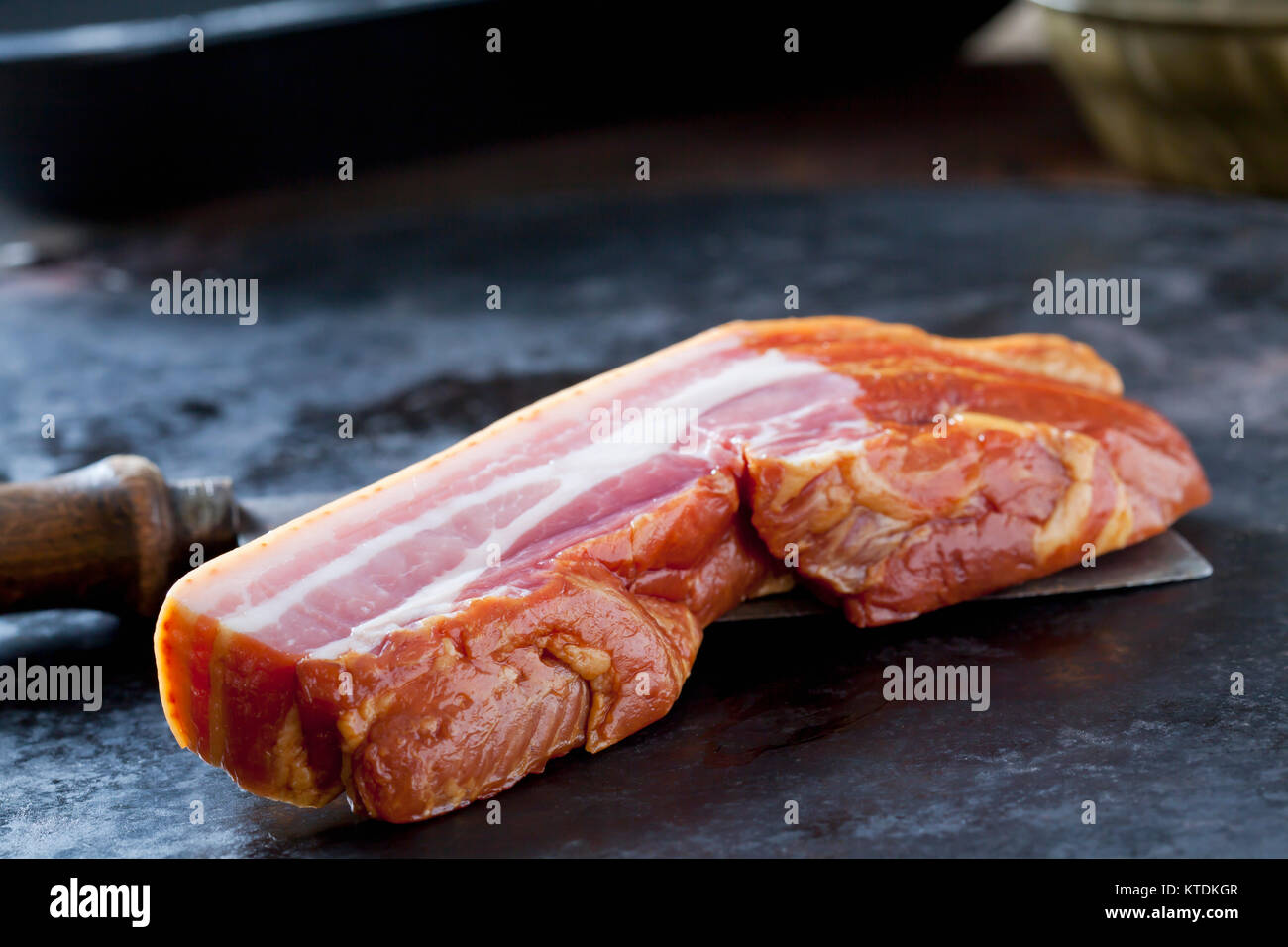 Streaky bacon with old cleaver on dark background Stock Photo - Alamy
