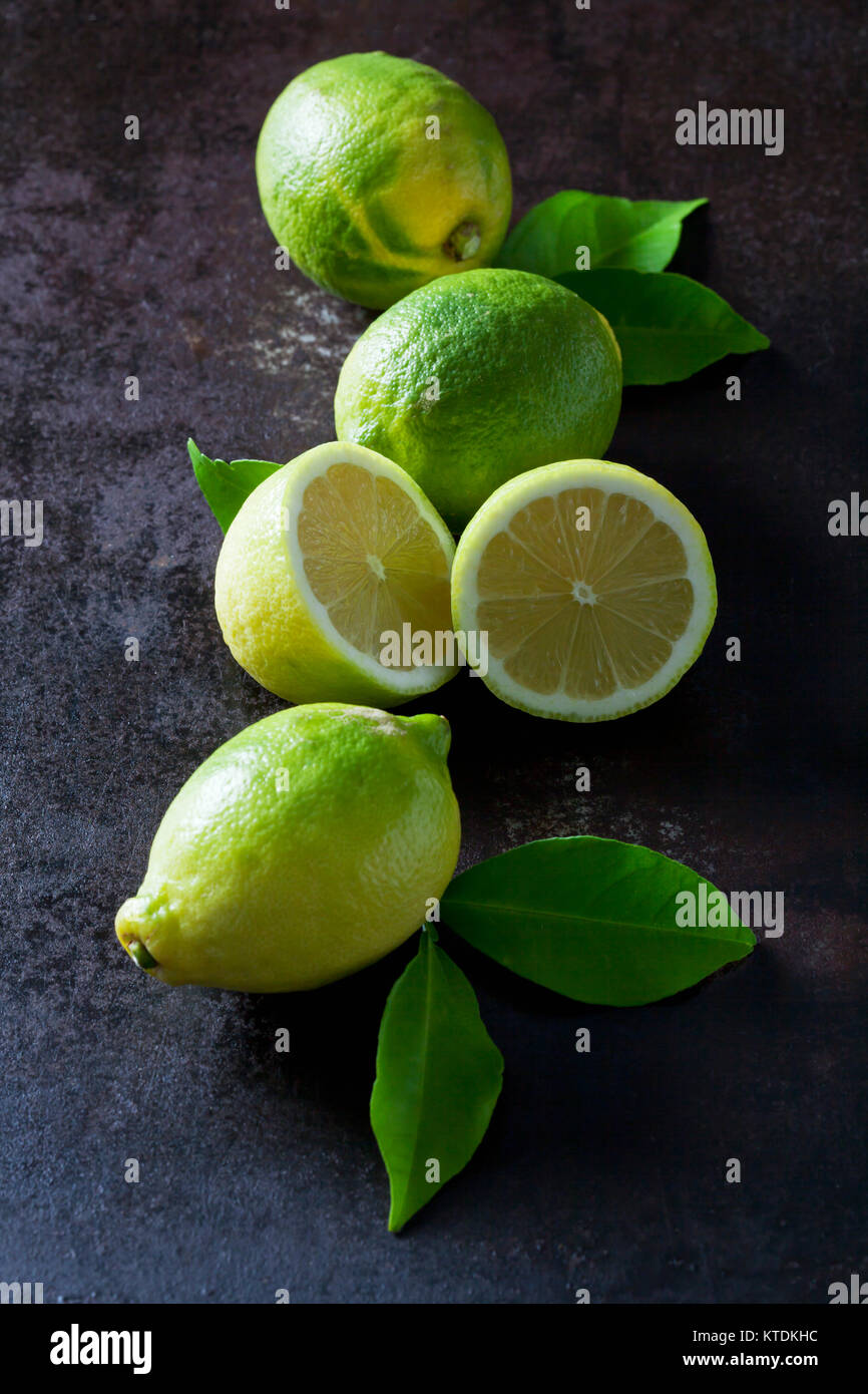 Green organic lemons on dark background Stock Photo - Alamy