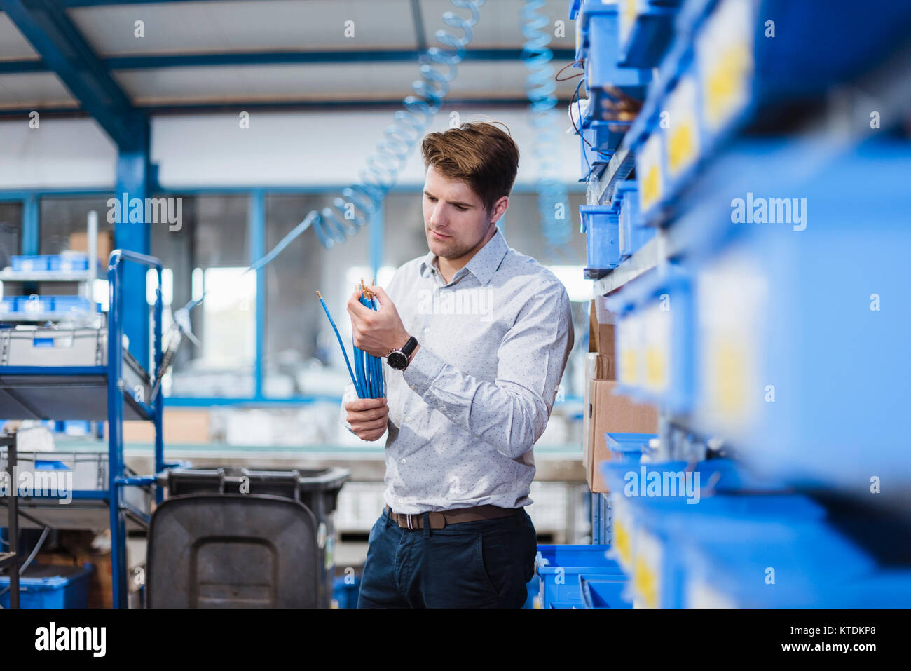 Businessman standing in shop floor, testing products Stock Photo - Alamy