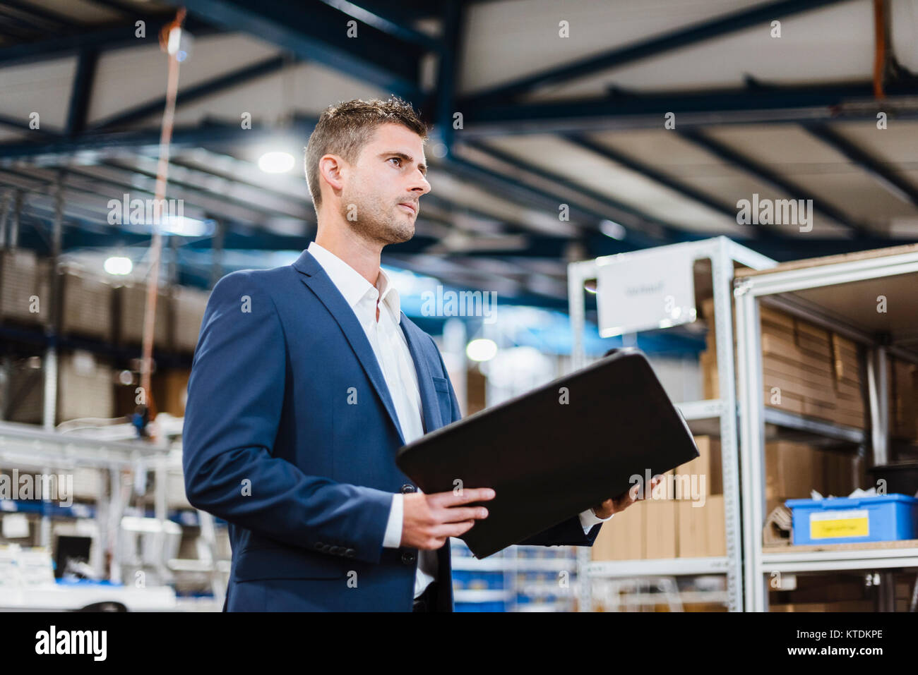 Portrait of a young manager in the shop floor, holding file Stock Photo ...