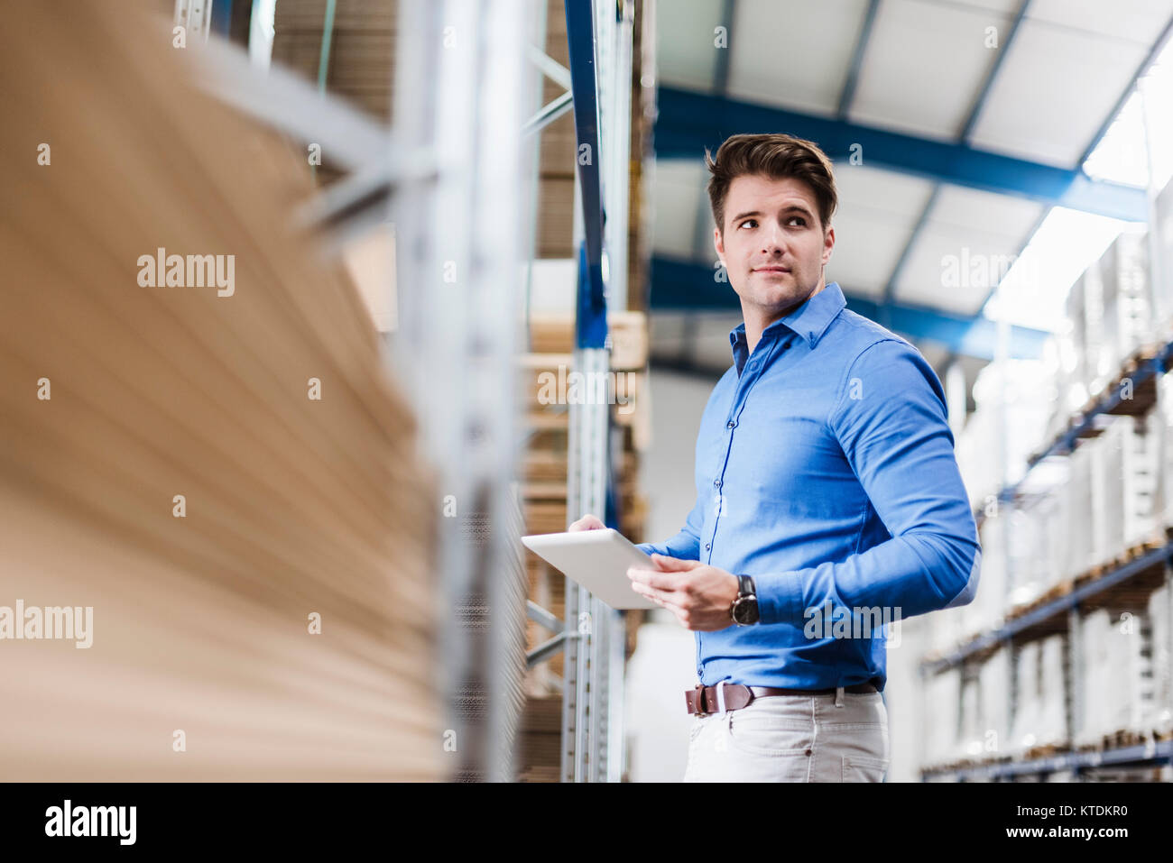 Young man working in warehouse, using digital tablet Stock Photo - Alamy