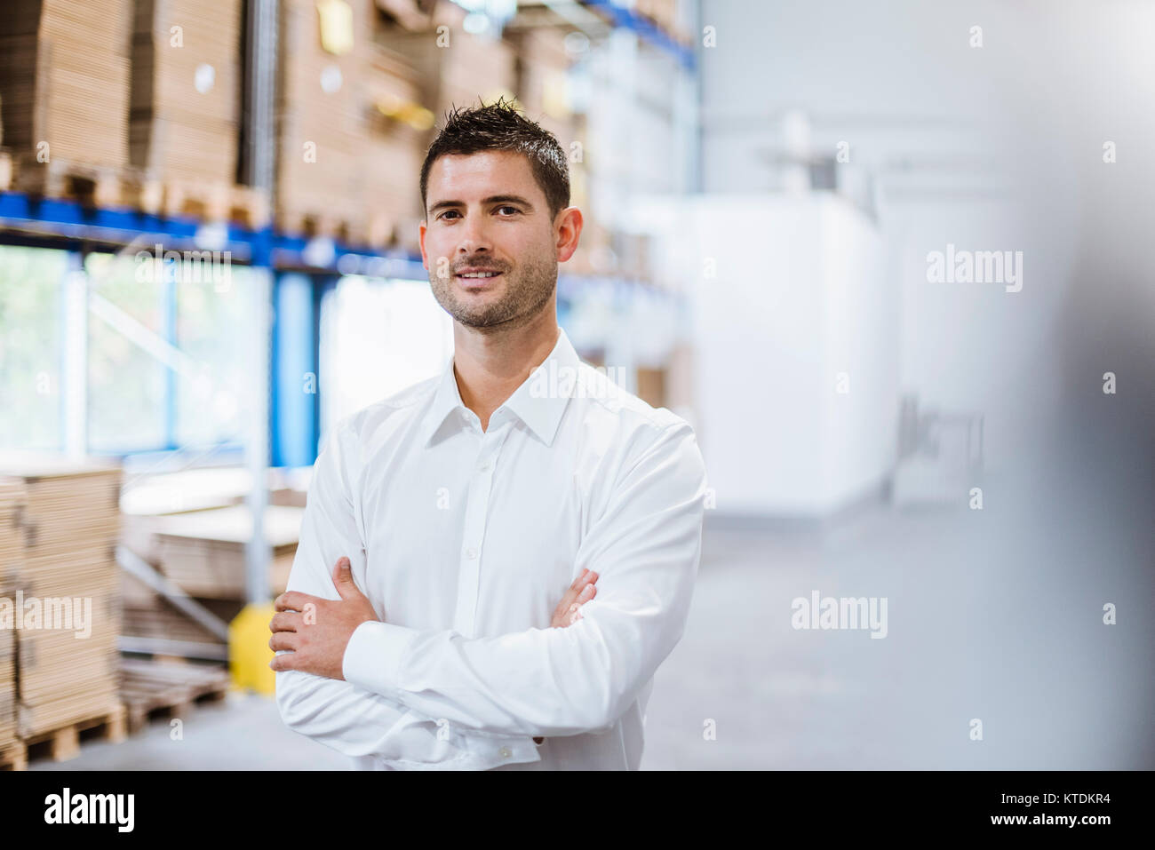 Businessman standing in warehouse, portrait Stock Photo - Alamy