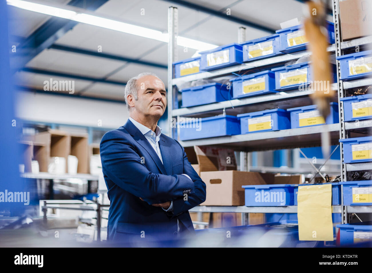 Business founder standing in his company with arms crossed, portrait ...
