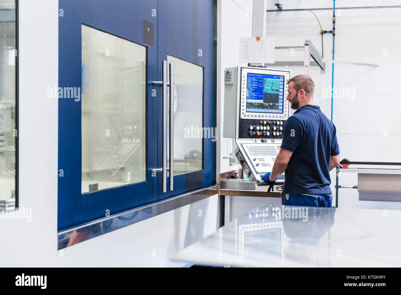 Man operating machine in industrial factory Stock Photo - Alamy