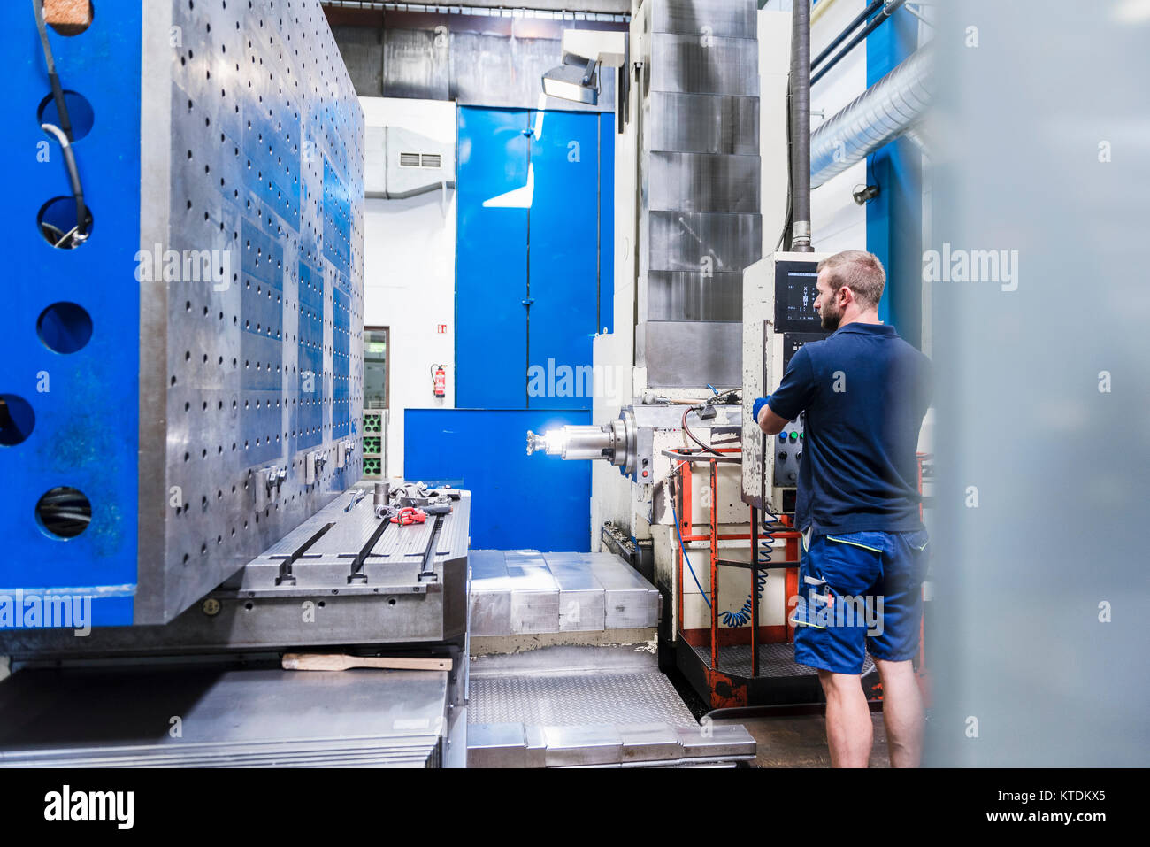 Man operating machine in industrial factory Stock Photo - Alamy