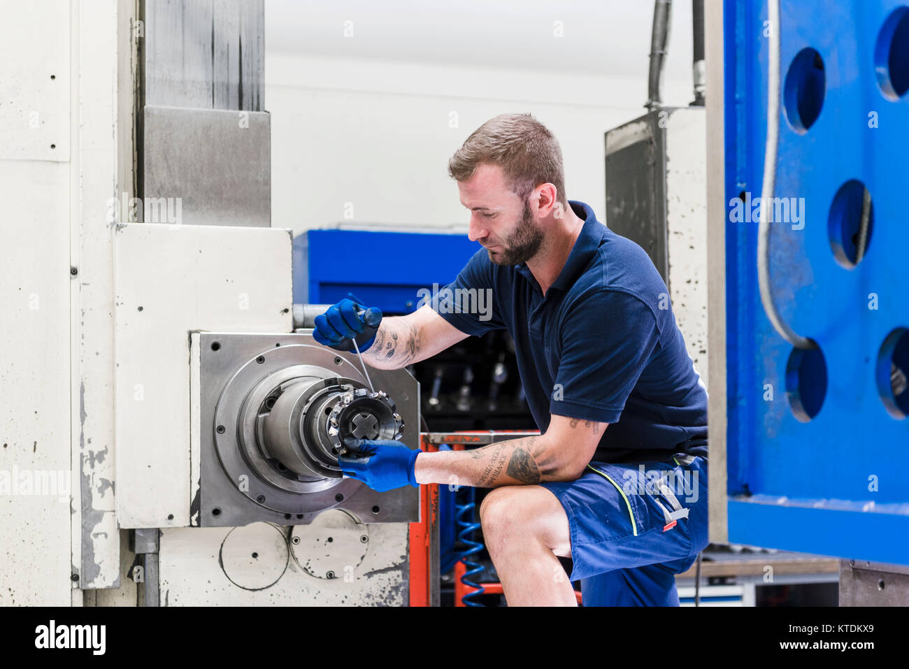 Man working on machine in industrial factory Stock Photo - Alamy