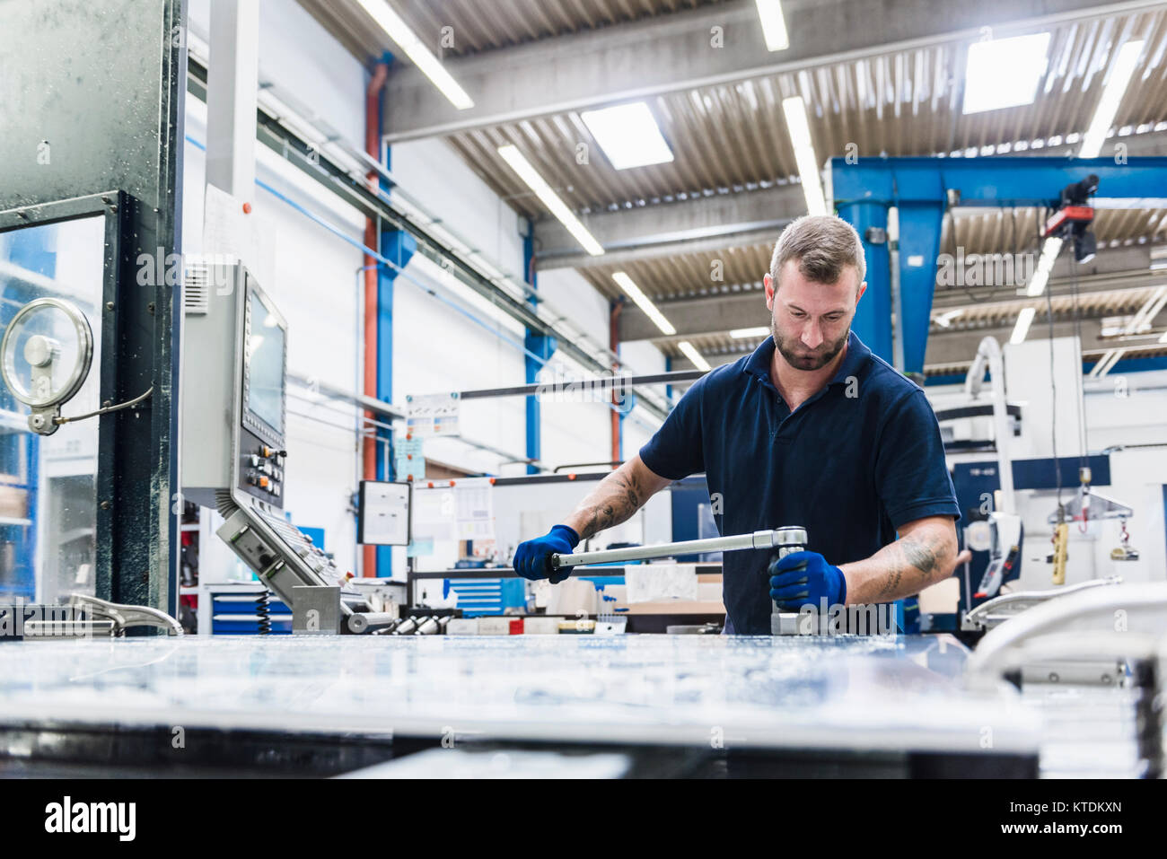 Man working on machine in industrial factory Stock Photo - Alamy