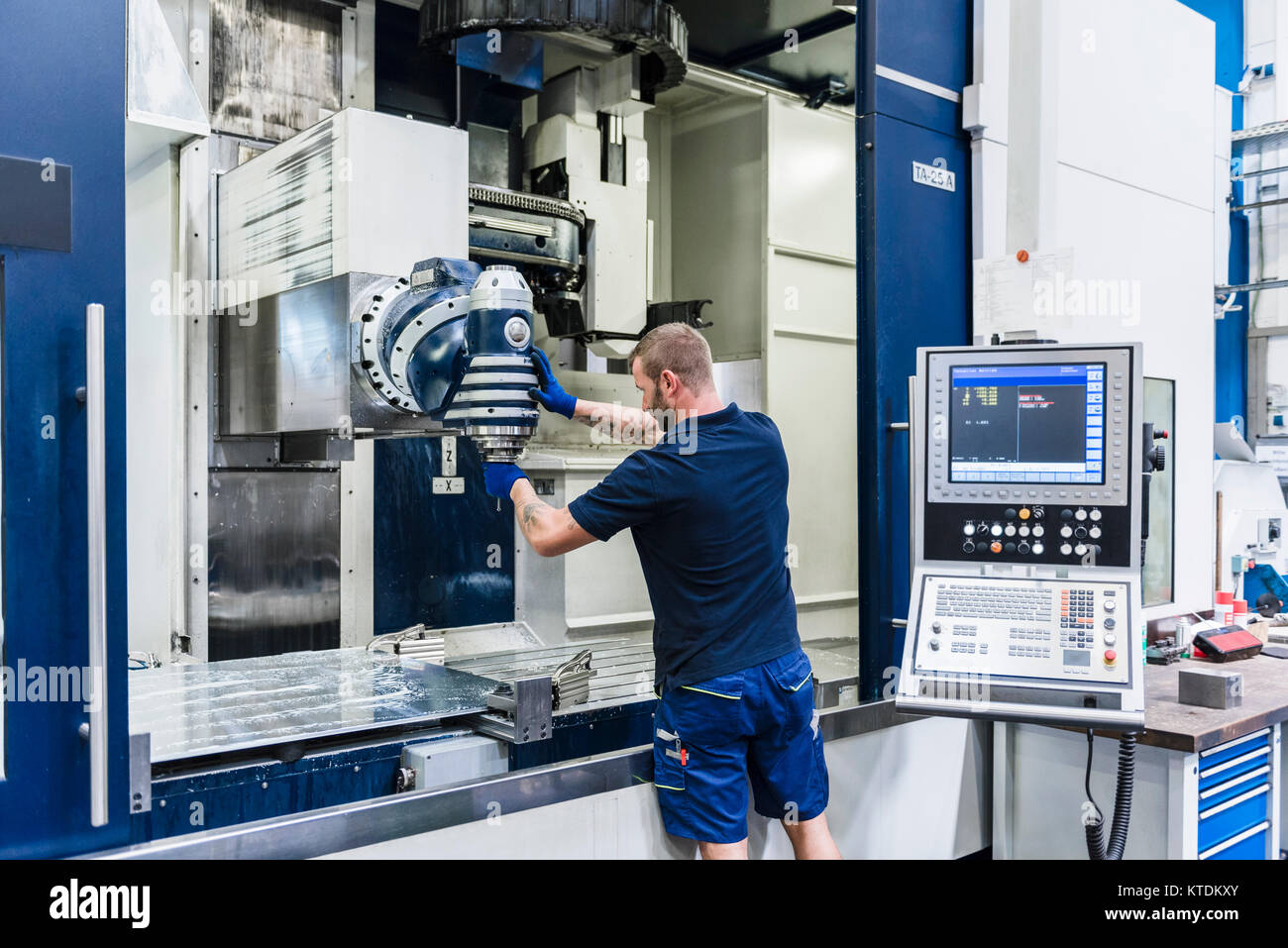 Man working on machine in industrial factory Stock Photo - Alamy