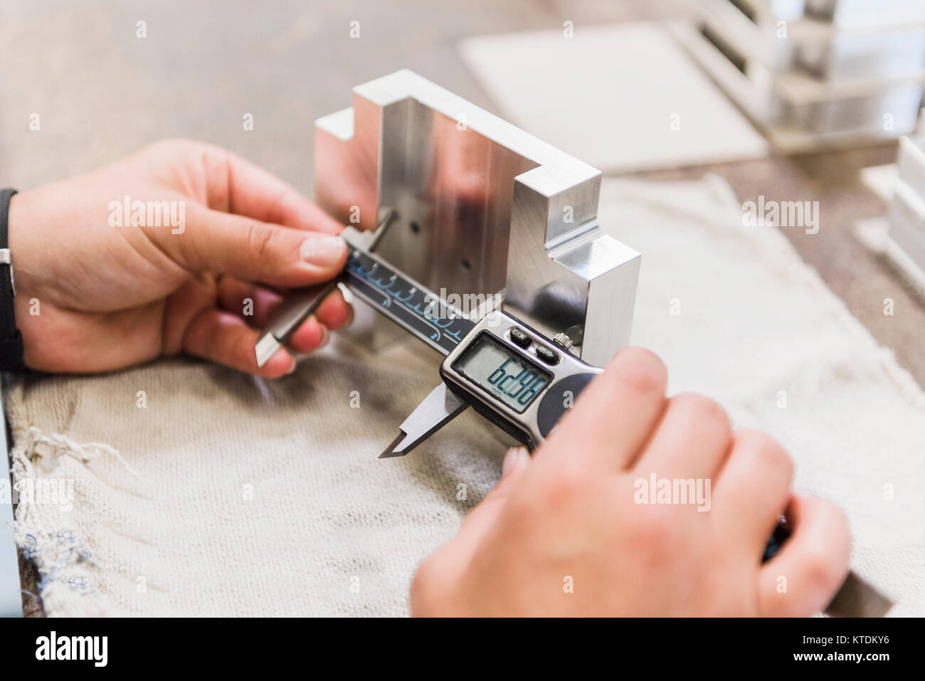 Detail of woman measuring metal workpiece Stock Photo - Alamy