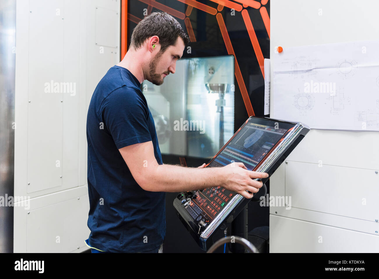 Man operating machine in industrial factory Stock Photo - Alamy