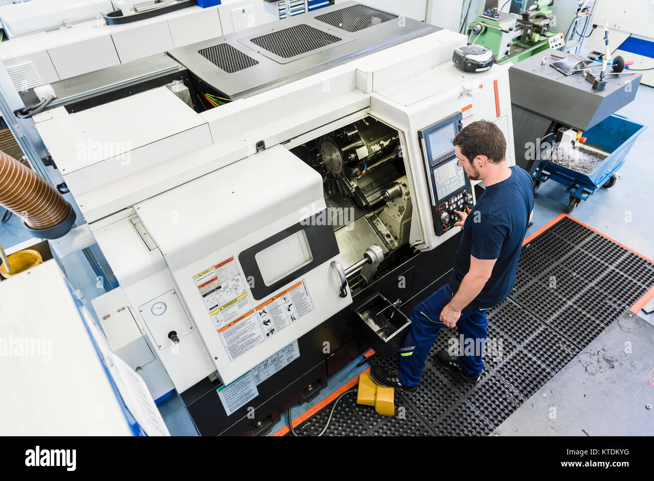 Man operating machine in industrial factory Stock Photo - Alamy