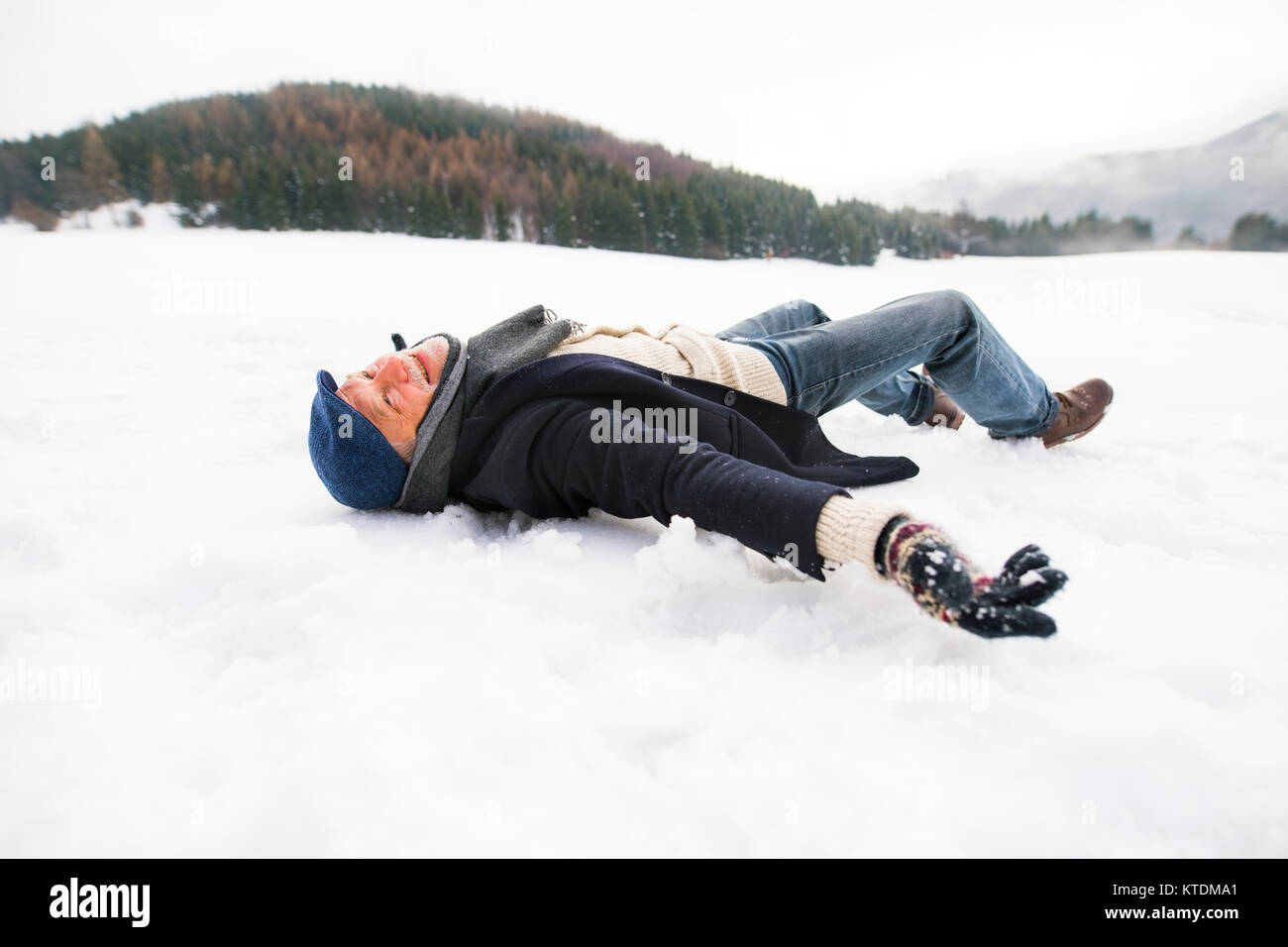 Senior man making a snow angel Stock Photo - Alamy