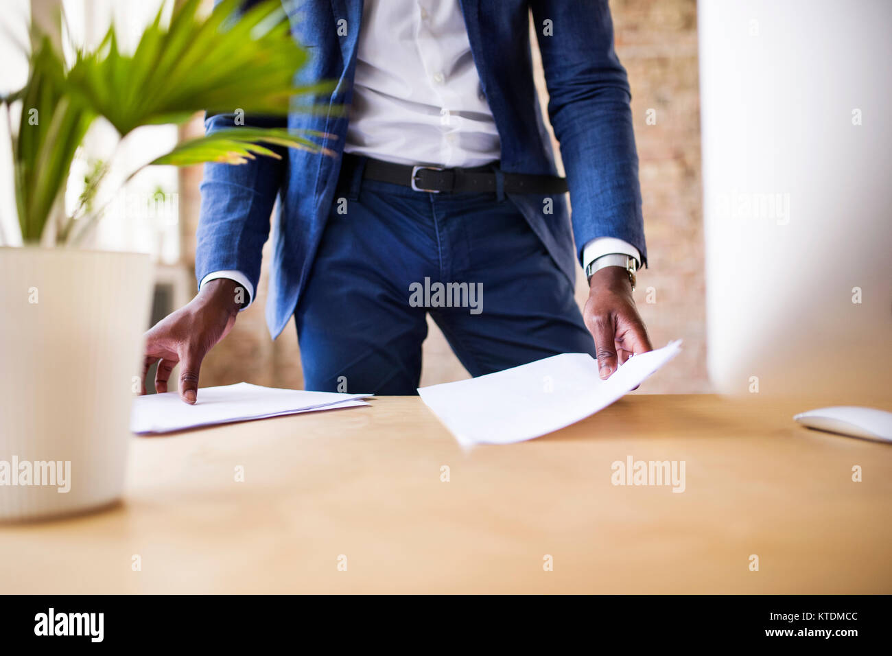 Close-up of businessman with papers at desk in office Stock Photo - Alamy
