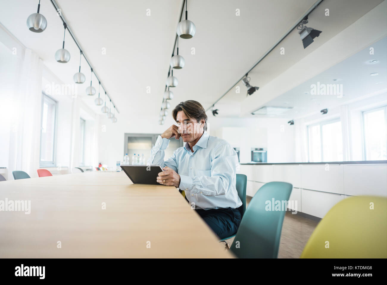 Businessman using tablet at table in office Stock Photo - Alamy