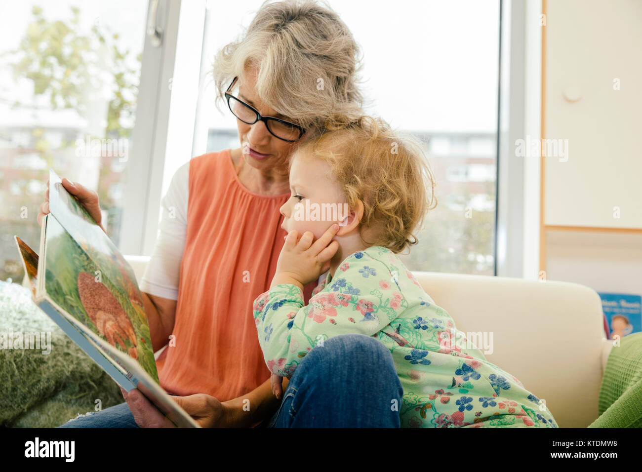 Pre-school teacher reading with child in kindergarten Stock Photo - Alamy