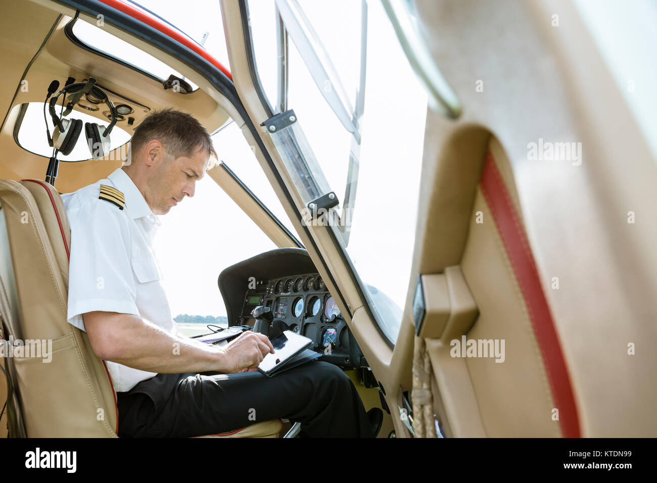 Pilot using tablet in cockpit of a helicopter Stock Photo - Alamy