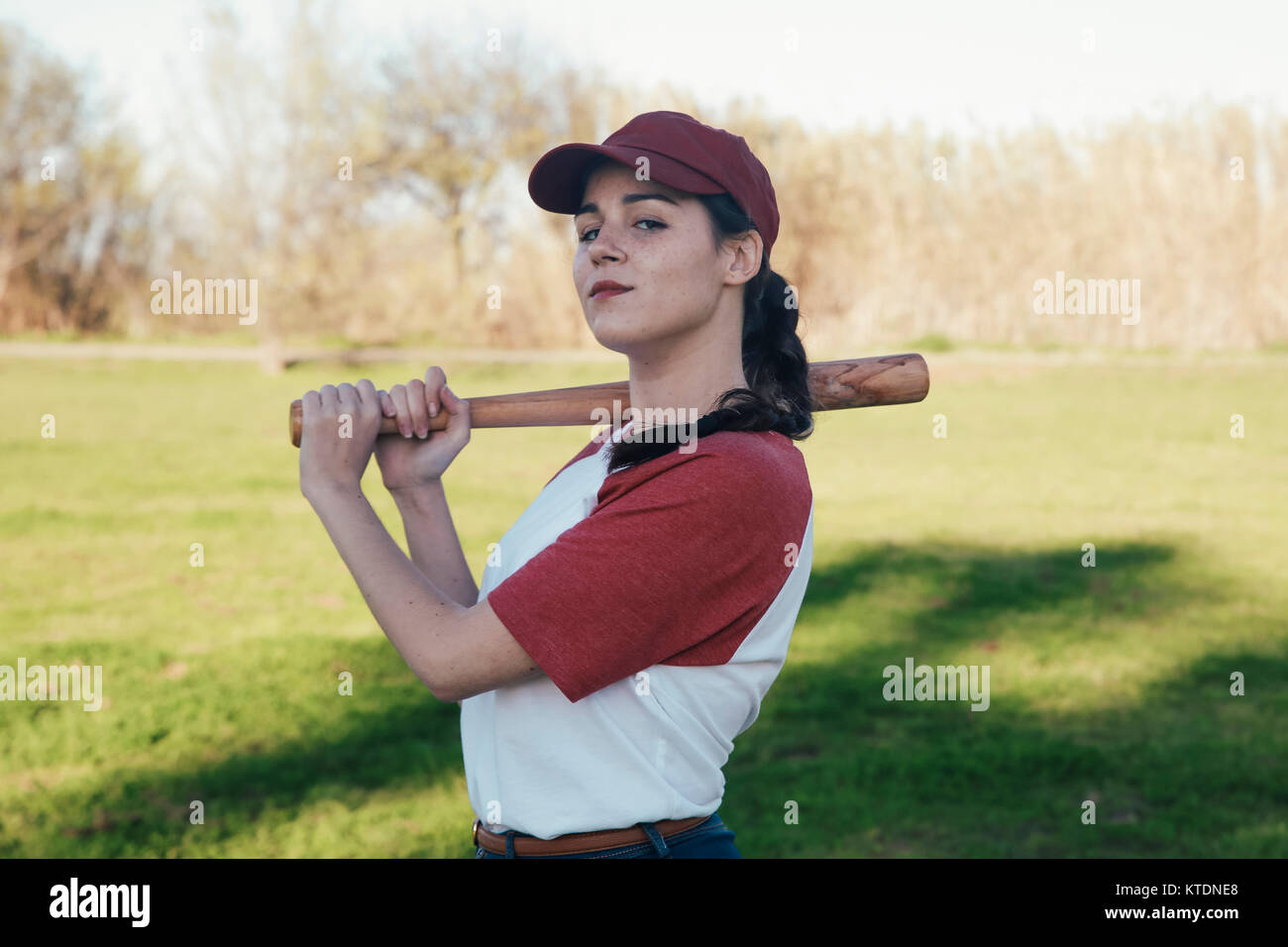 Portrait of young woman with baseball bat in park Stock Photo - Alamy