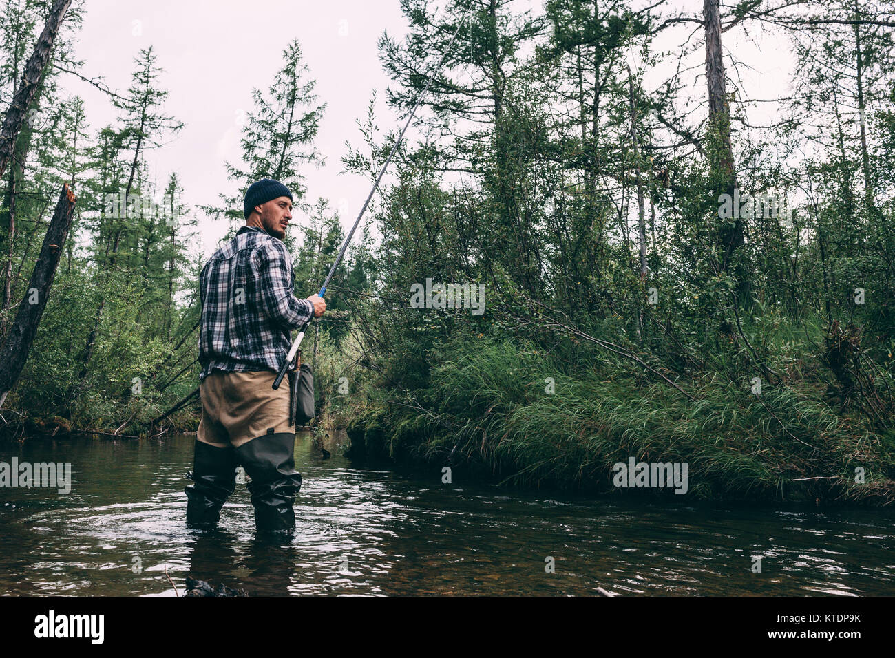 Angler standing in river with waders Stock Photo - Alamy