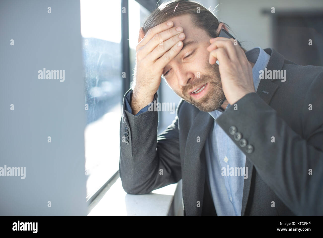 Frustrated businessman in office talking on the phone Stock Photo - Alamy