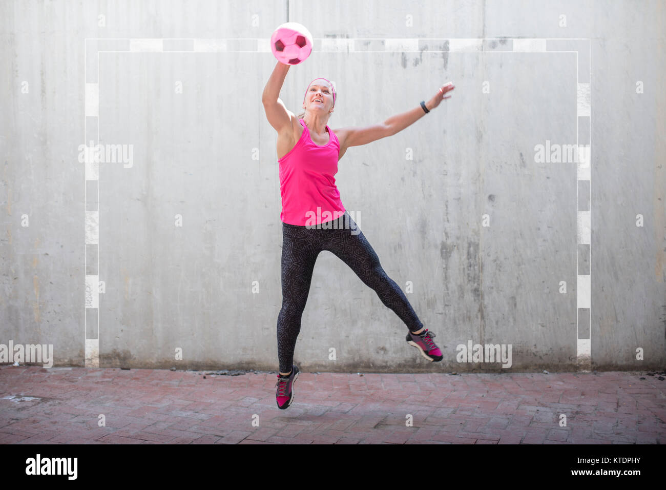 Woman jumping to catch a ball Stock Photo - Alamy