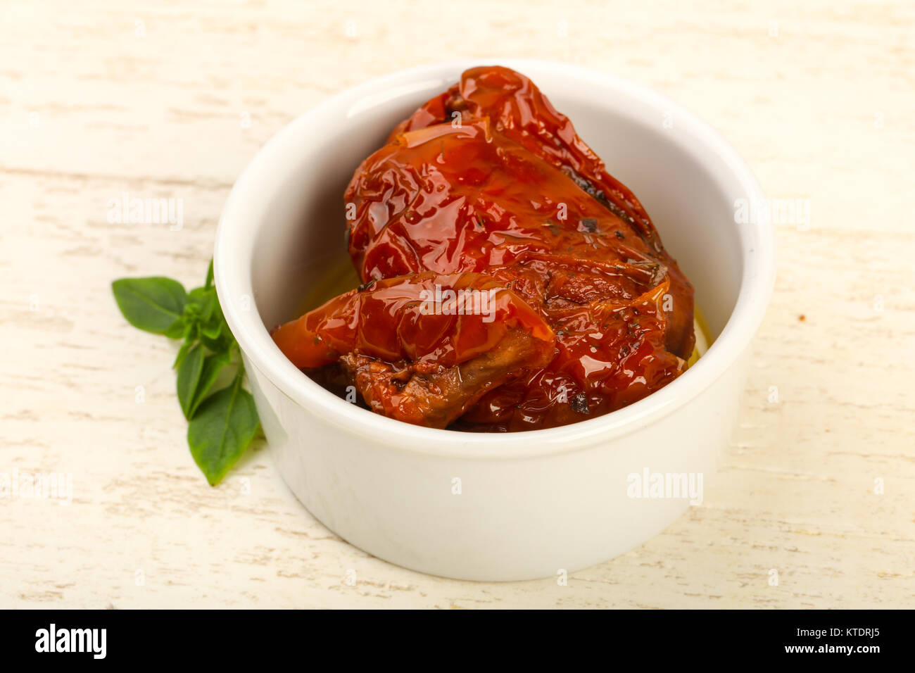 Dried tomato in olive oil with basil leaves Stock Photo - Alamy