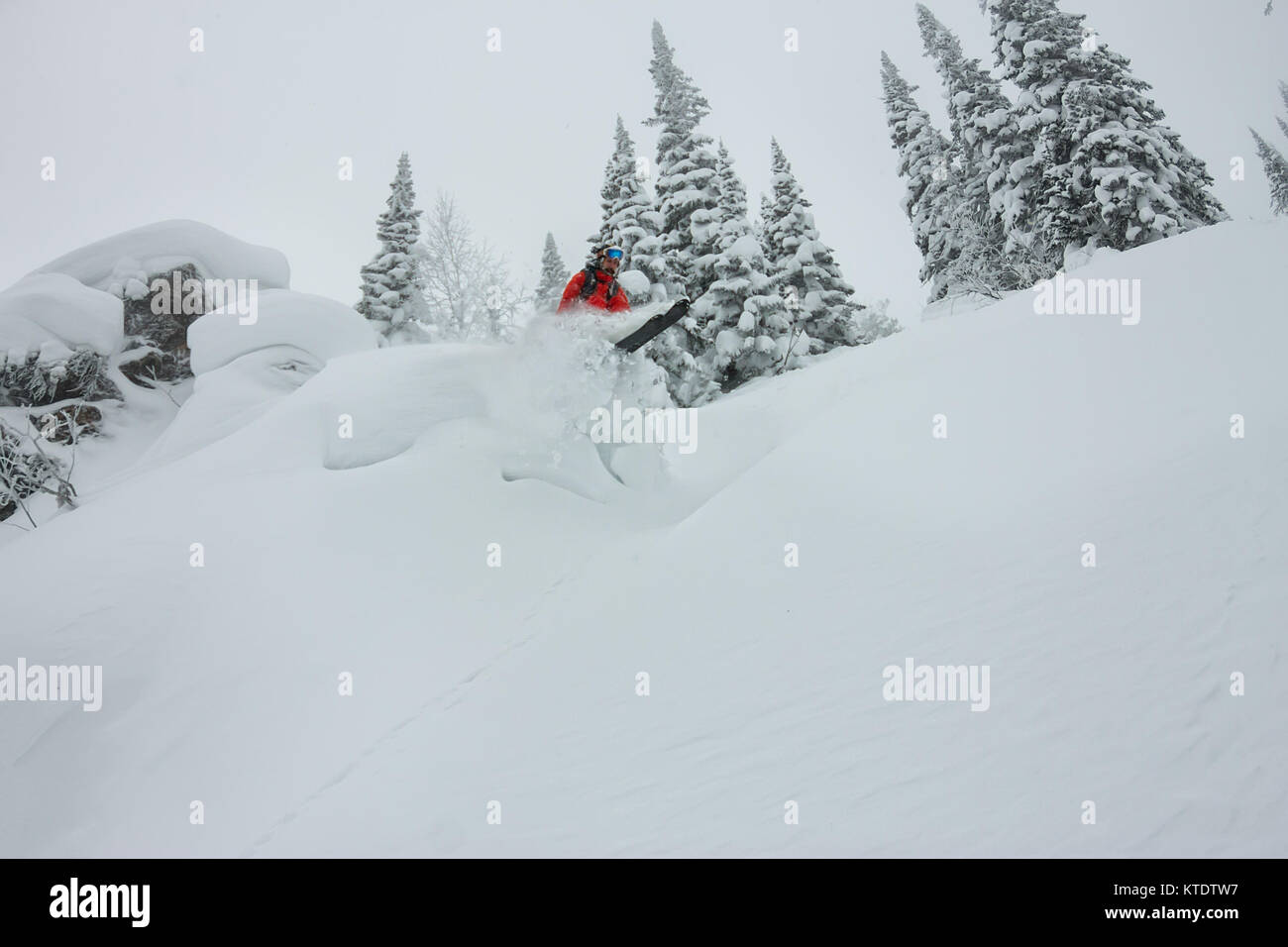 Skier freerider jumping from a snow ramp in the sun on a background of ...