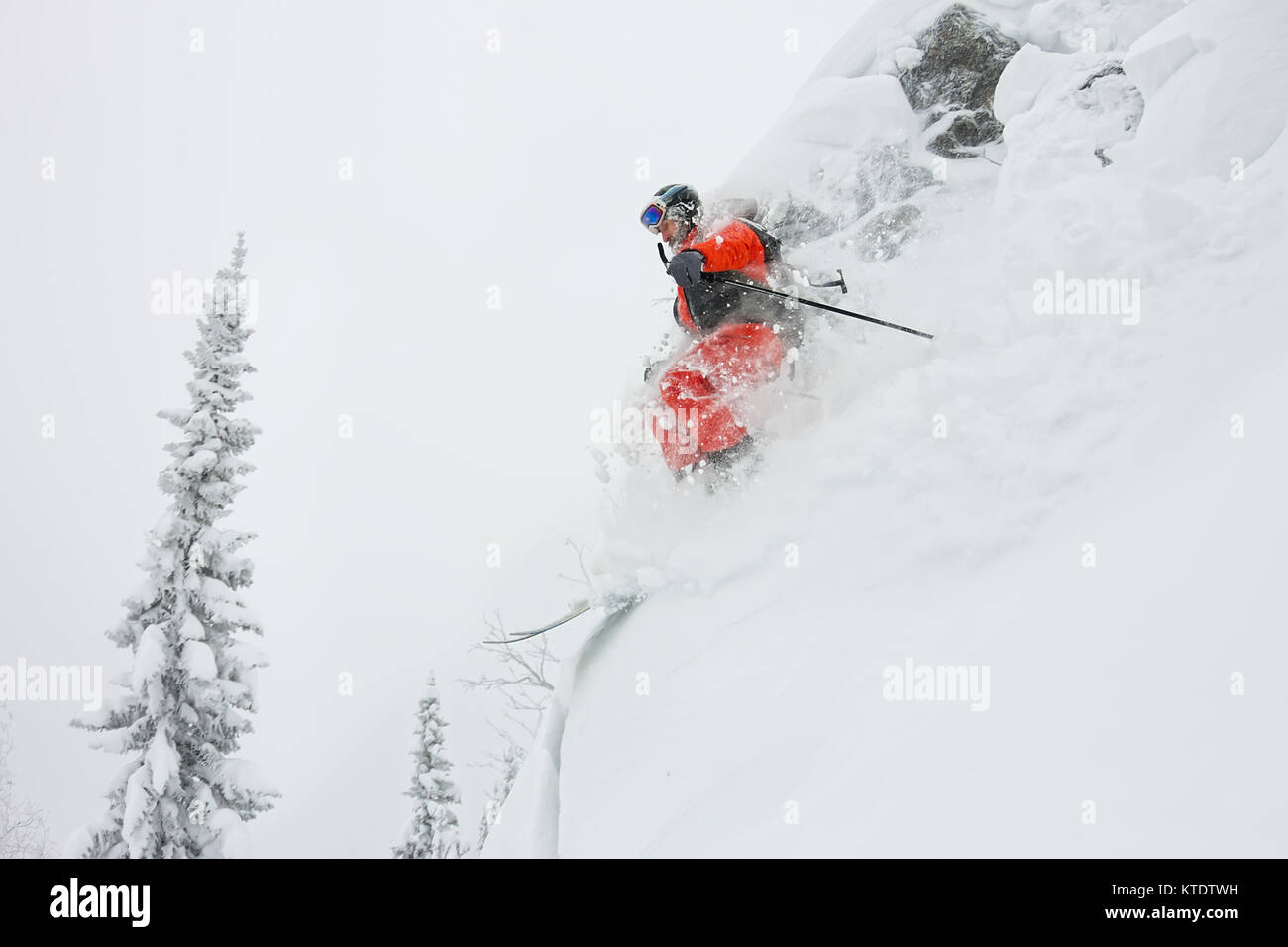 Skier freerider jumping from a snow ramp in the sun on a background of ...