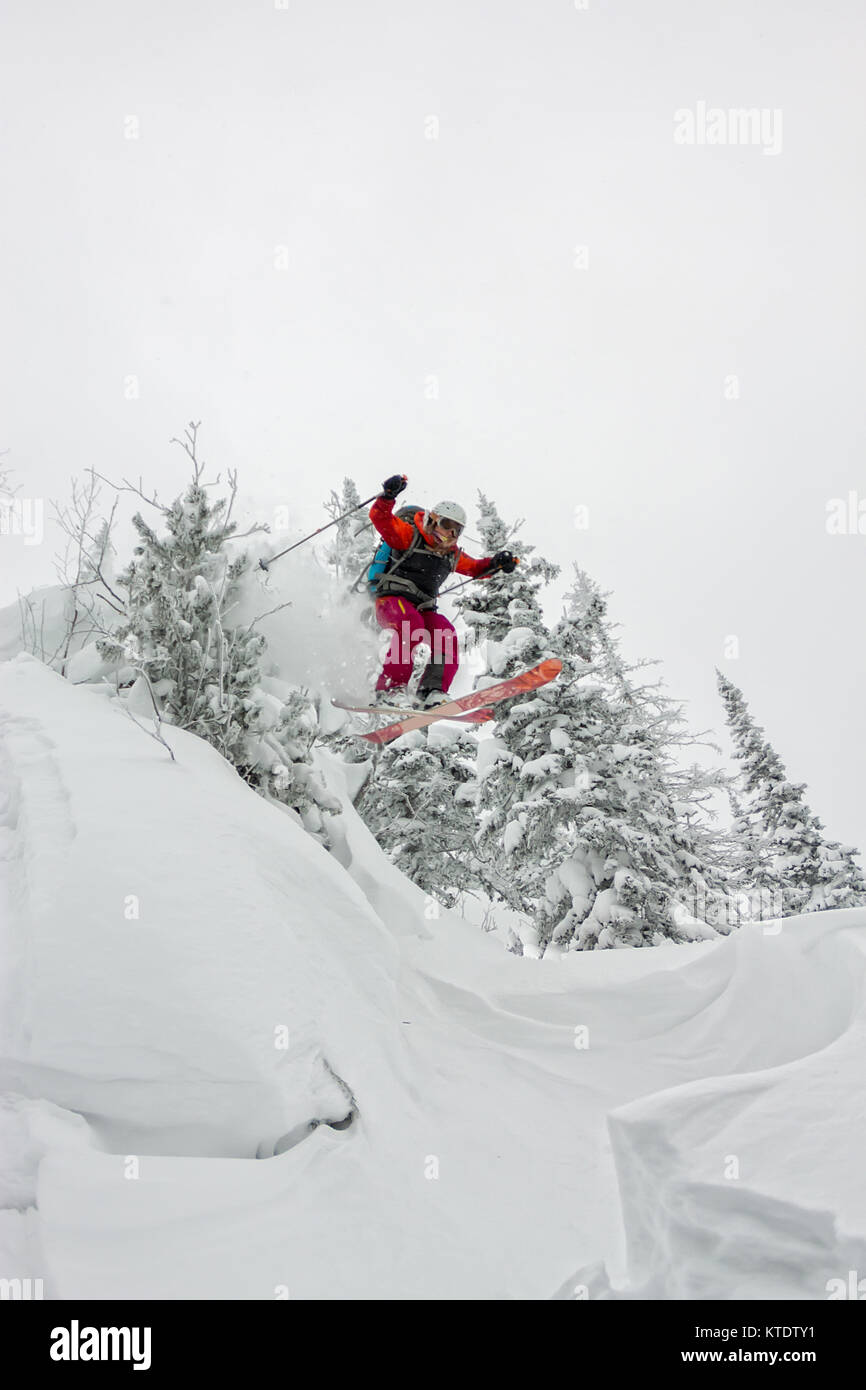 Skier freerider jumping from a snow ramp in the sun on a background of ...