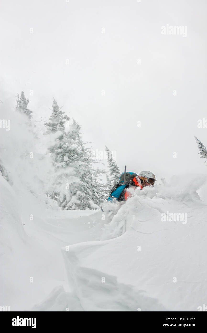 Skier freerider jumping from a snow ramp in the sun on a background of ...