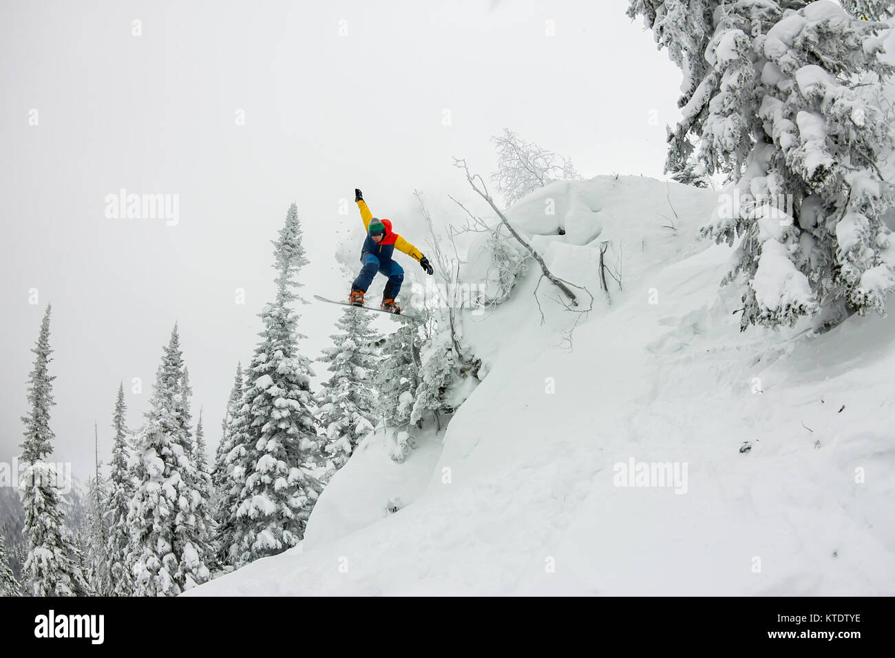 Snowboarder freerider jumping from a snow ramp in the sun on a ...