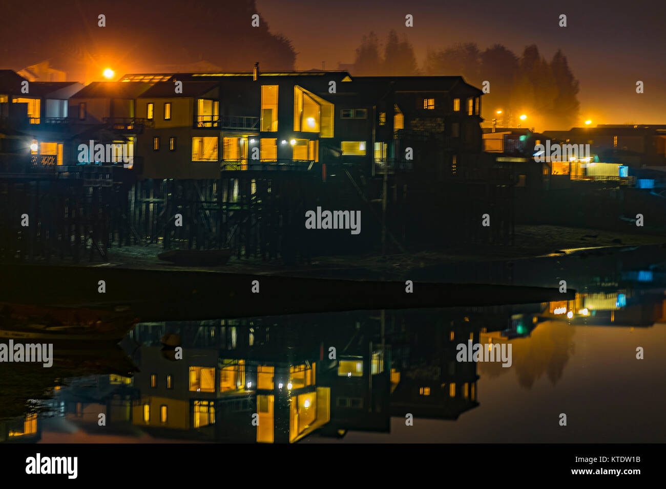 Night scene at typical palafito houses at lake in Castro city, Chiloe ...