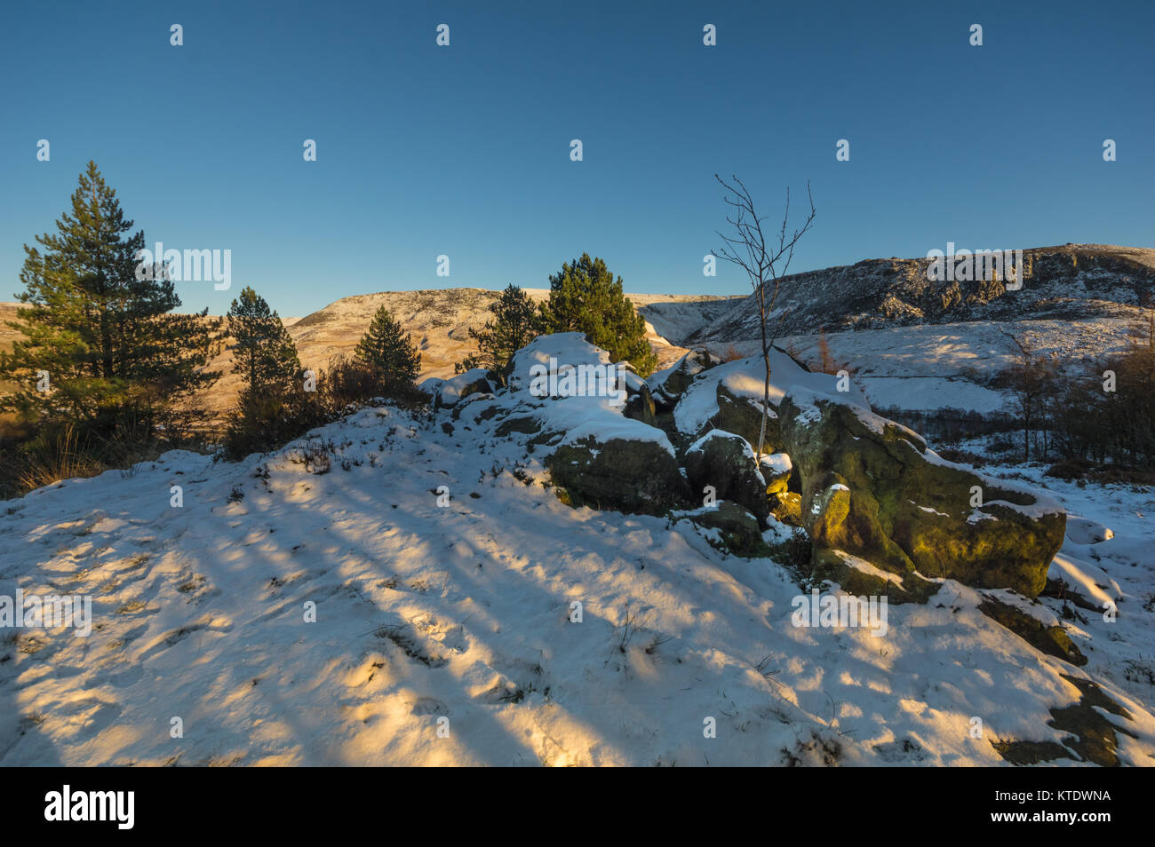 Rocks, trees, snow and blue sky at Binn Green, Greenfield, Saddleworth ...