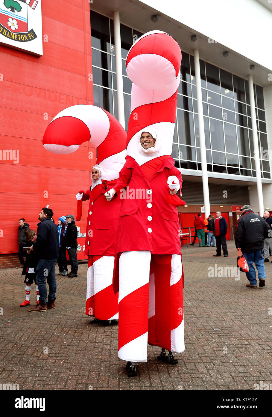 Festively dressed stilt walkers greet fans outside the stadium during ...