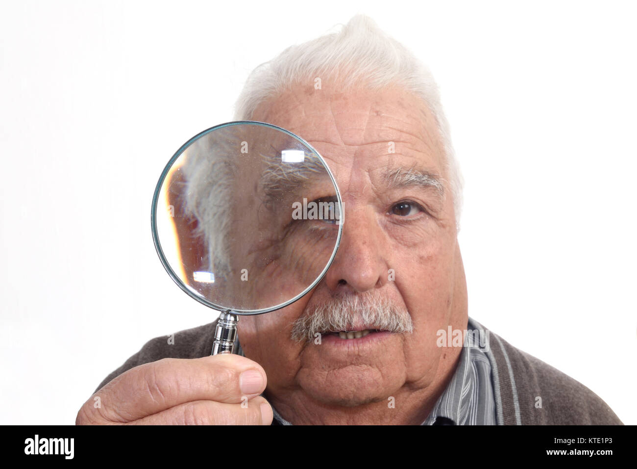 Curious man peering through magnifying glass Stock Photo - Alamy