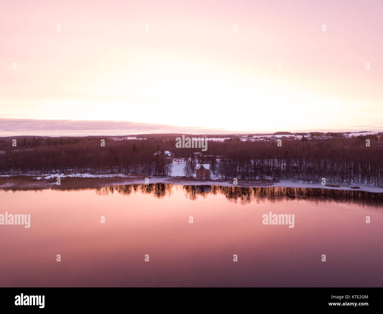 Beautiful colorful sunrise over a half frozen lake during winter. Tartu ...