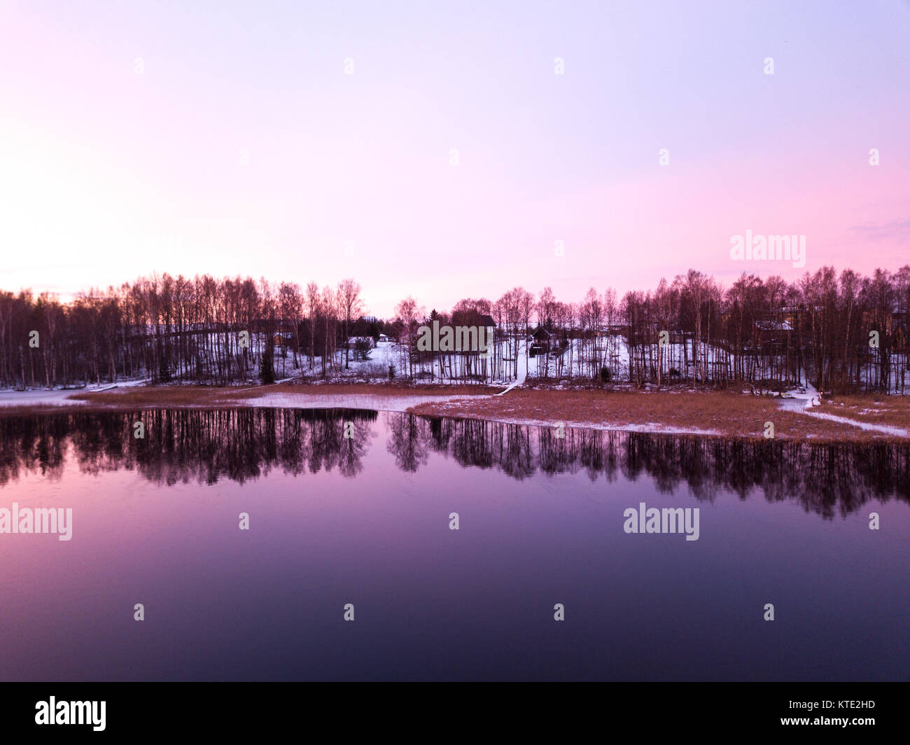Beautiful colorful sunrise over a half frozen lake during winter. Tartu ...