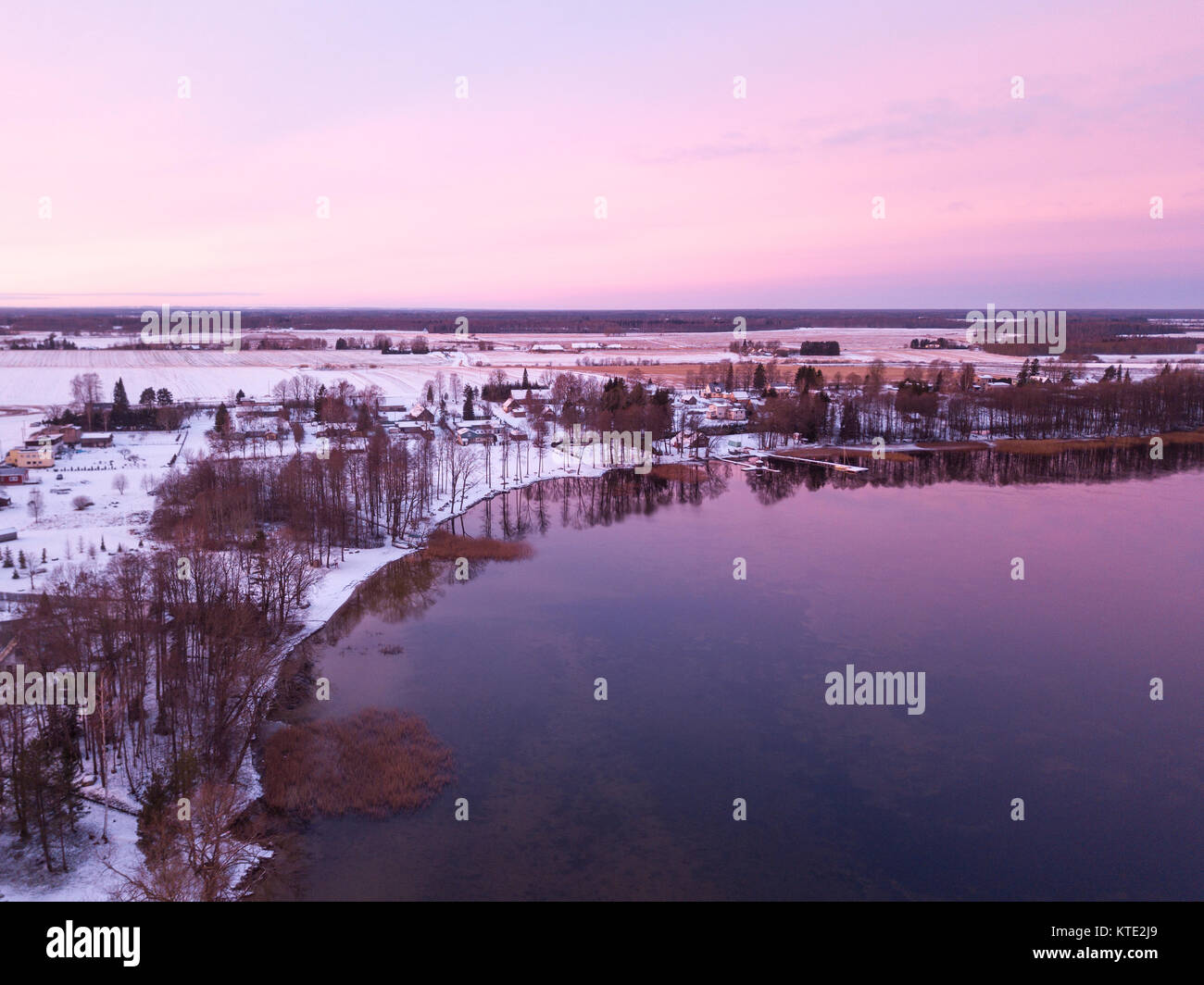 Beautiful colorful sunrise over a half frozen lake during winter. Tartu ...