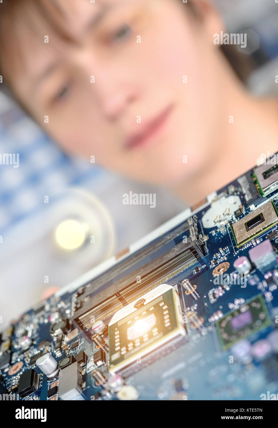 Closeup on motherboard observed by a tech for possible defects Stock ...