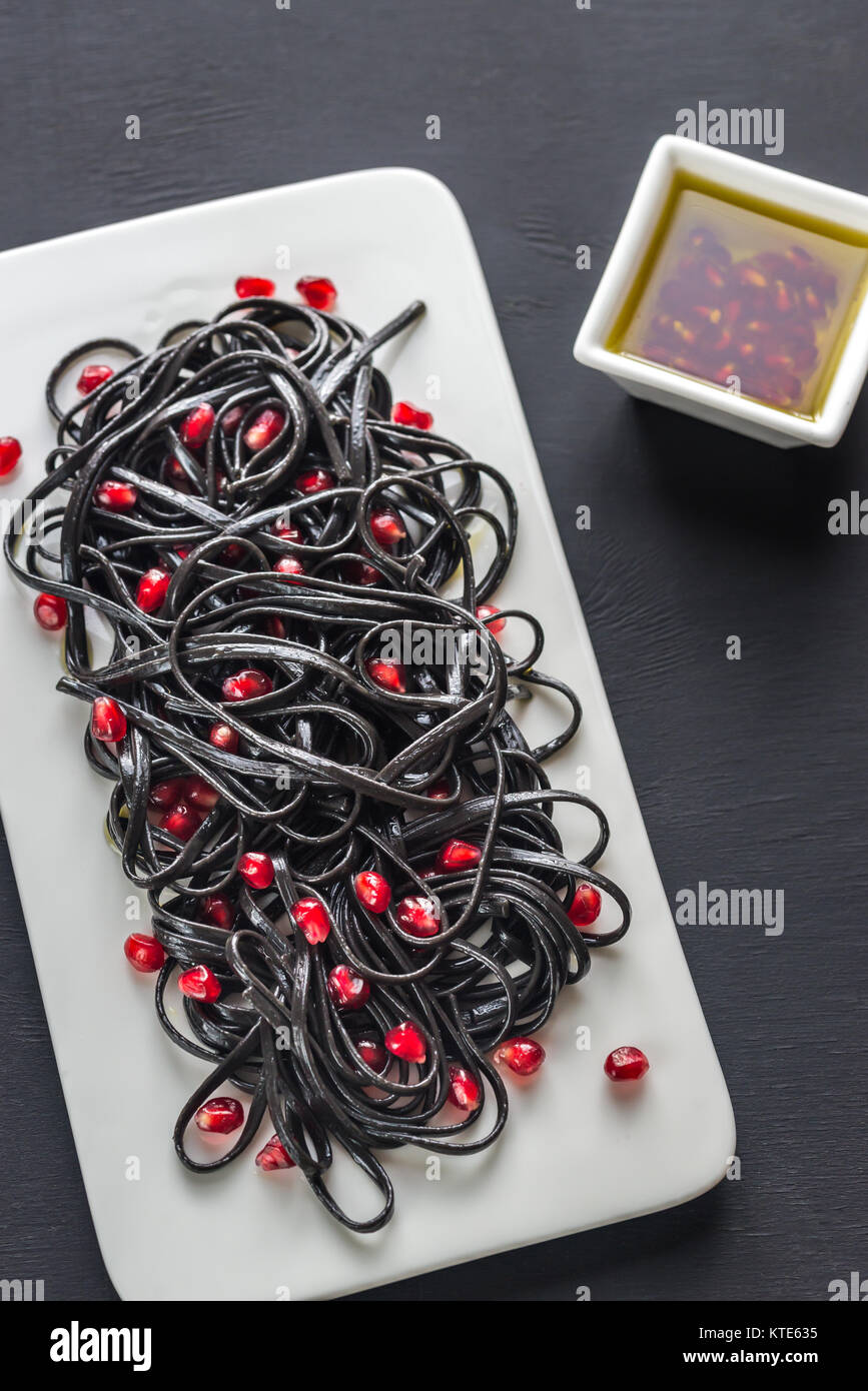 Black pasta with pomegranate seeds Stock Photo - Alamy