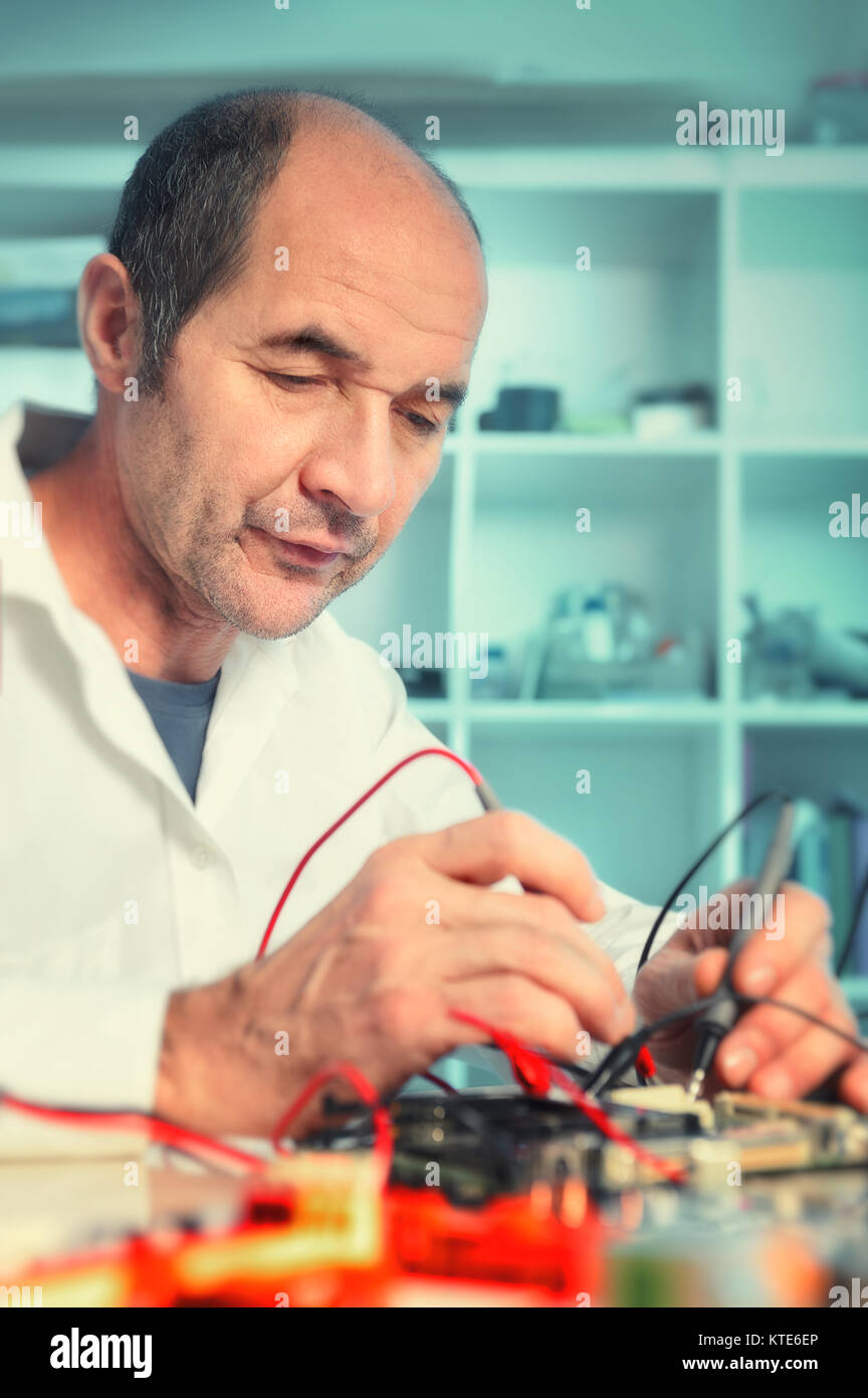 Senior male tech tests electronic equipment. This image is toned Stock ...