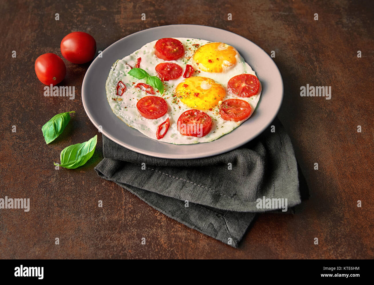 Healthy food breakfast menu. Fried eggs with cherry tomatos and chili ...