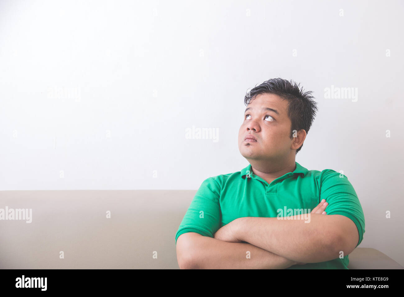 Fat man thinking and looking up to copyspace Stock Photo - Alamy