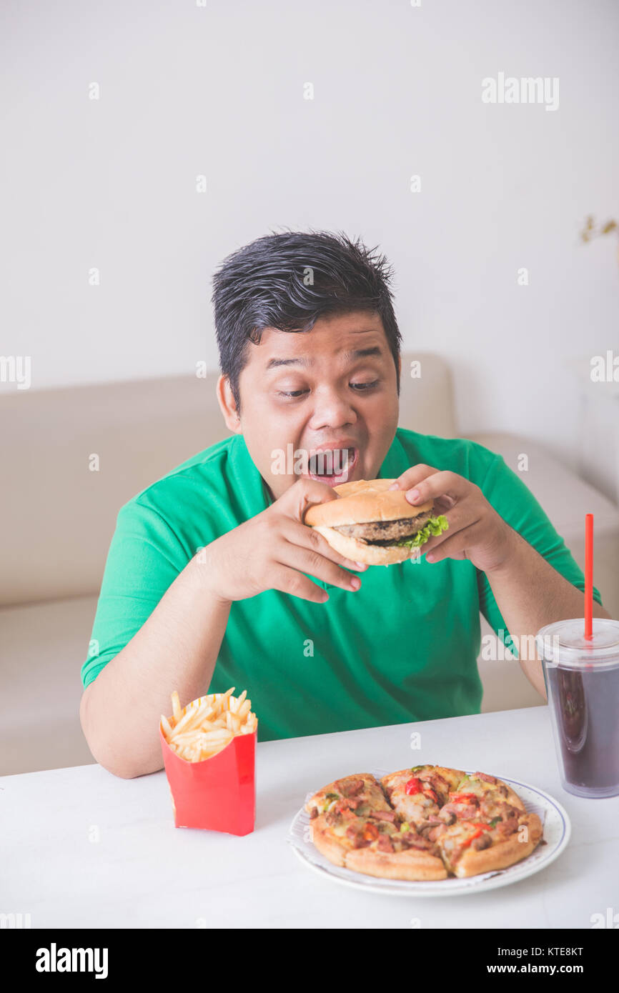 Hungry lazy overweight man eating hi-res stock photography and images ...