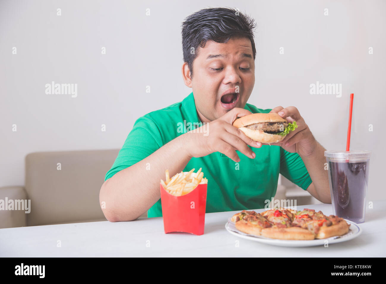 Obese man eating junk food hi-res stock photography and images - Alamy