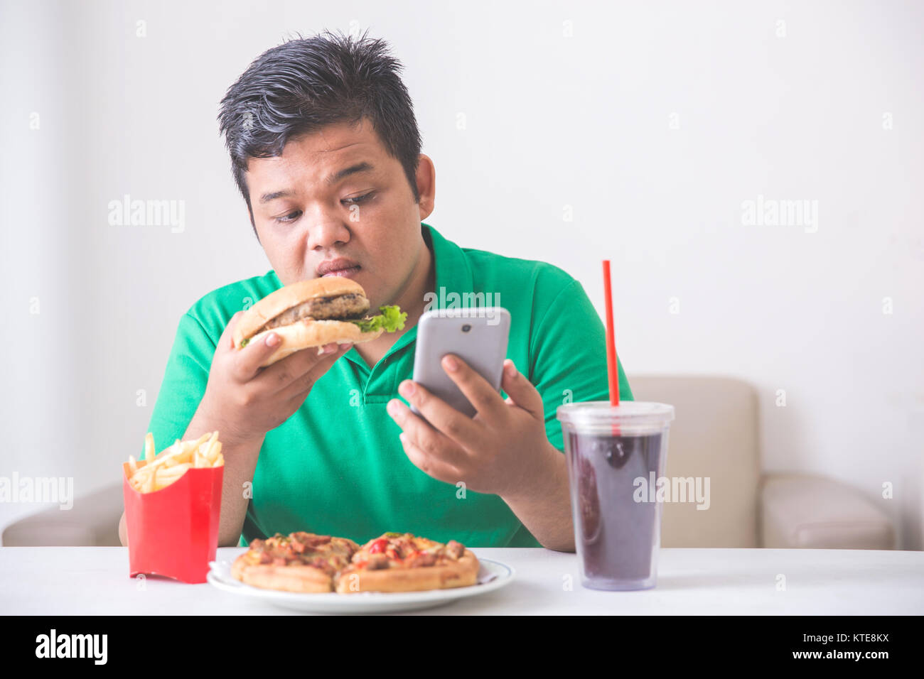 Obese man eating junk food hi-res stock photography and images - Alamy