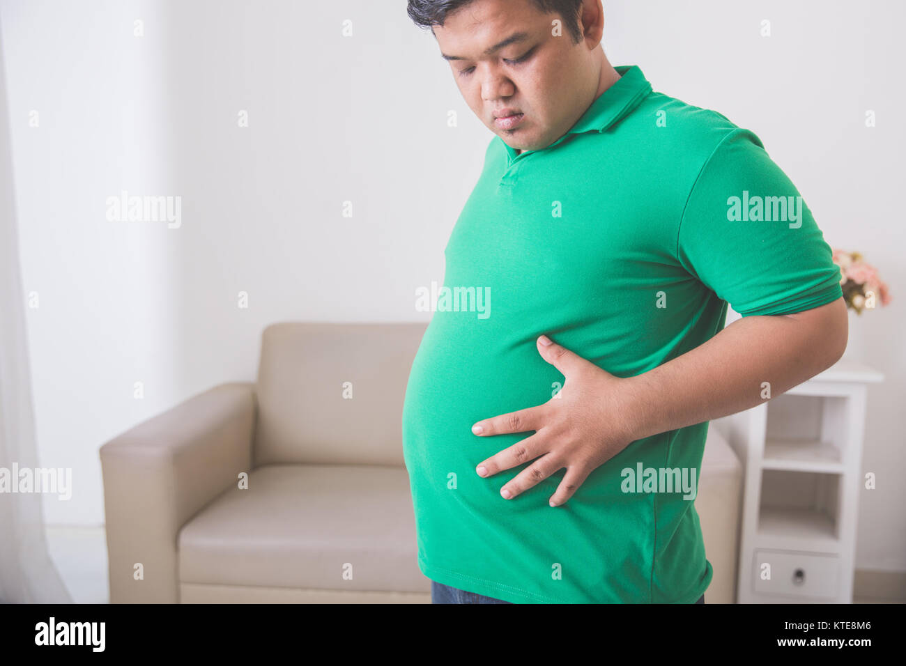 obese man holding his big belly Stock Photo - Alamy