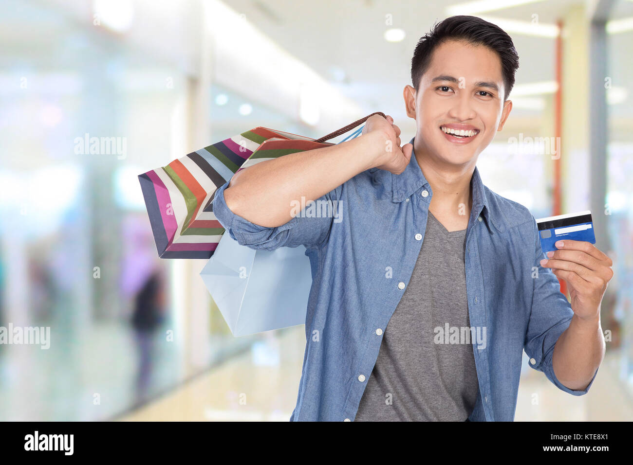 Young asian man holding shopping bags and credit card, close up Stock ...
