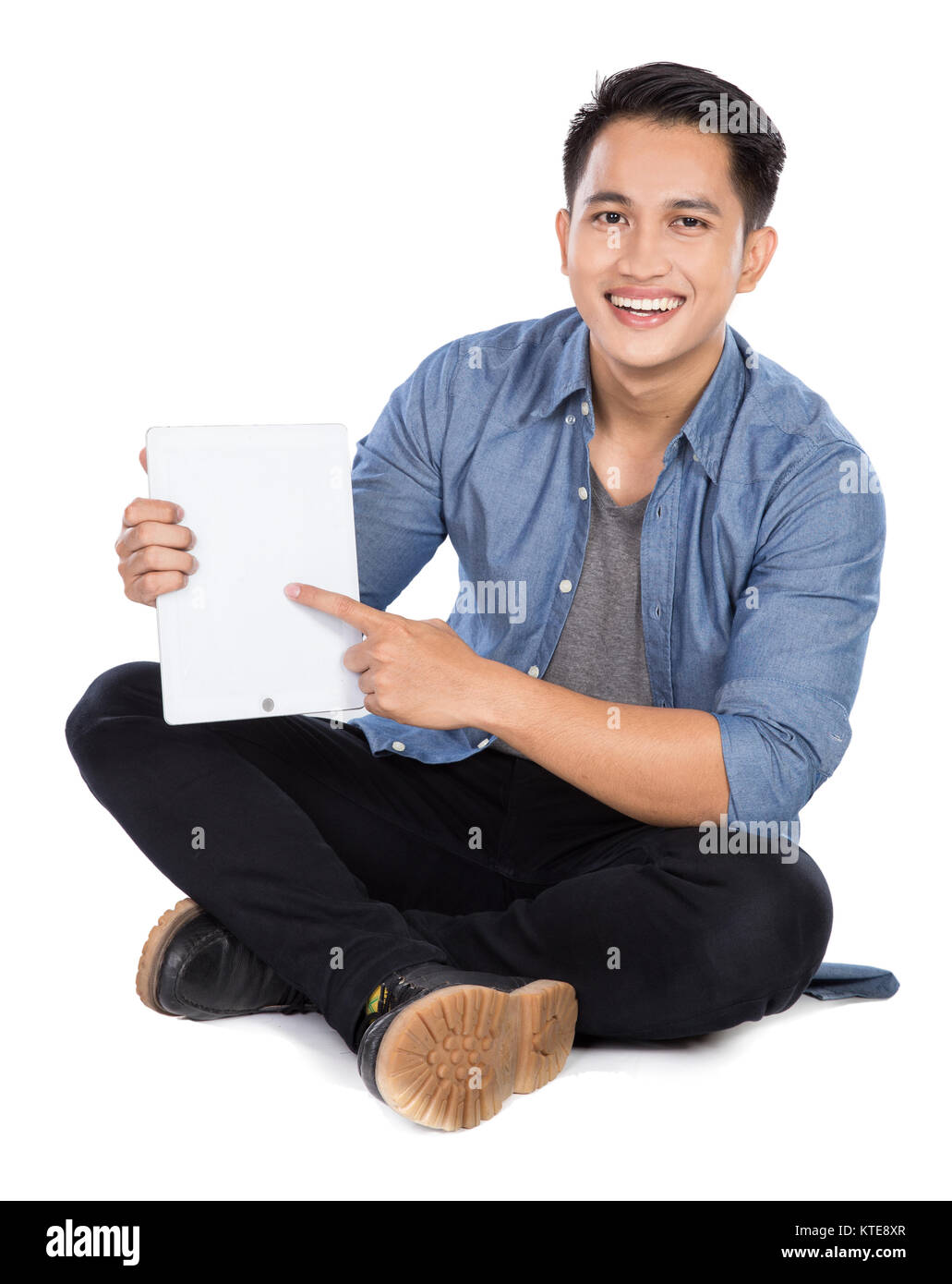 Young asian man pointing at something on the tablet pc, while si Stock ...