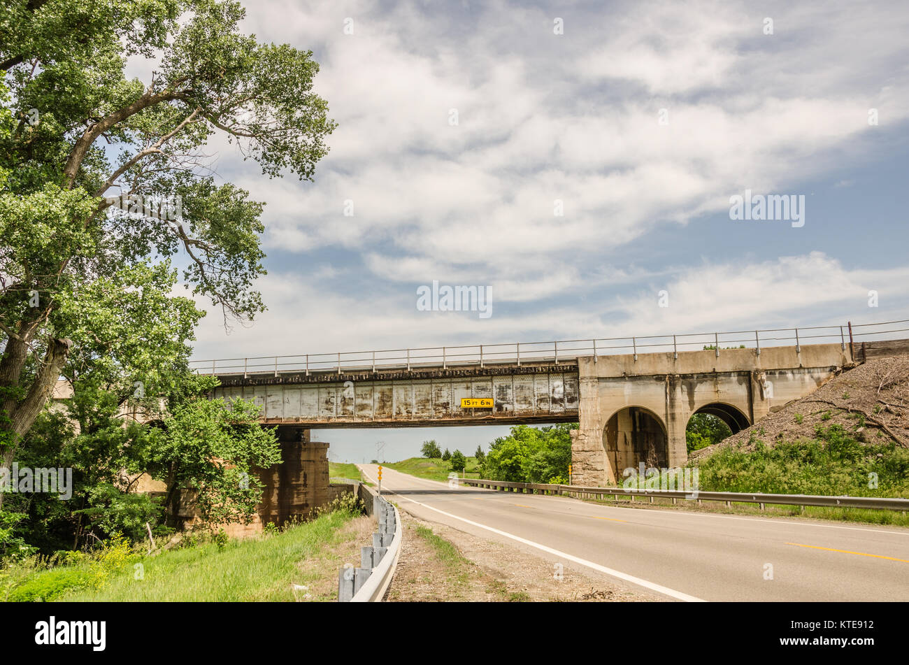 Rusty railroad bridge crossing over a rural road in the United States ...