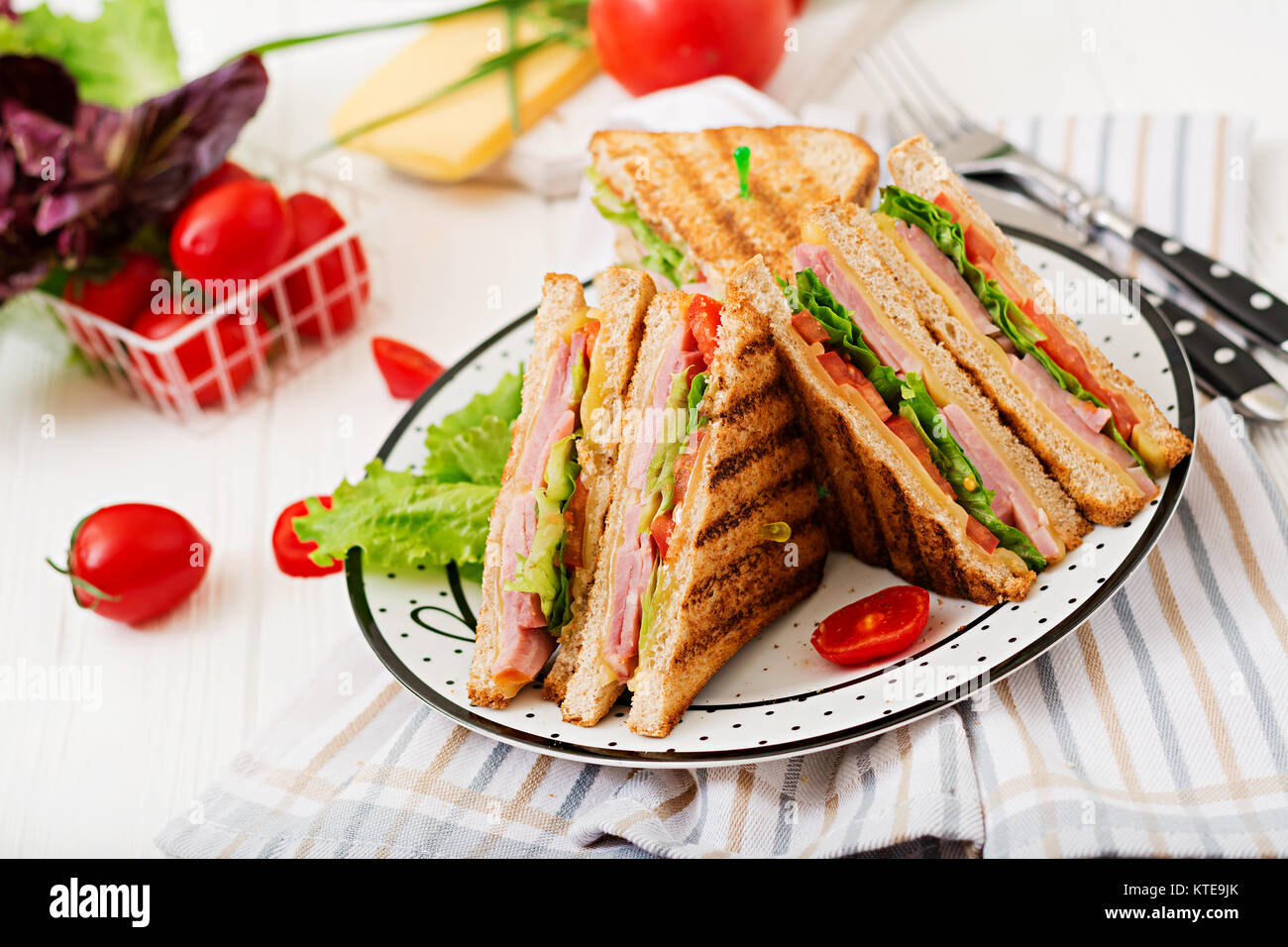 Club sandwich - panini with ham, cheese, tomato and herbs Stock Photo ...